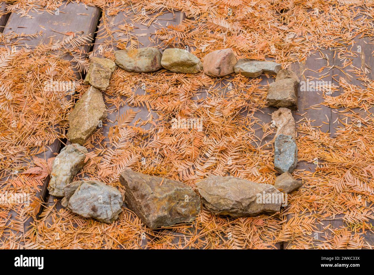 Rock frame on wooden picnic table covered with scattered leaves in ...