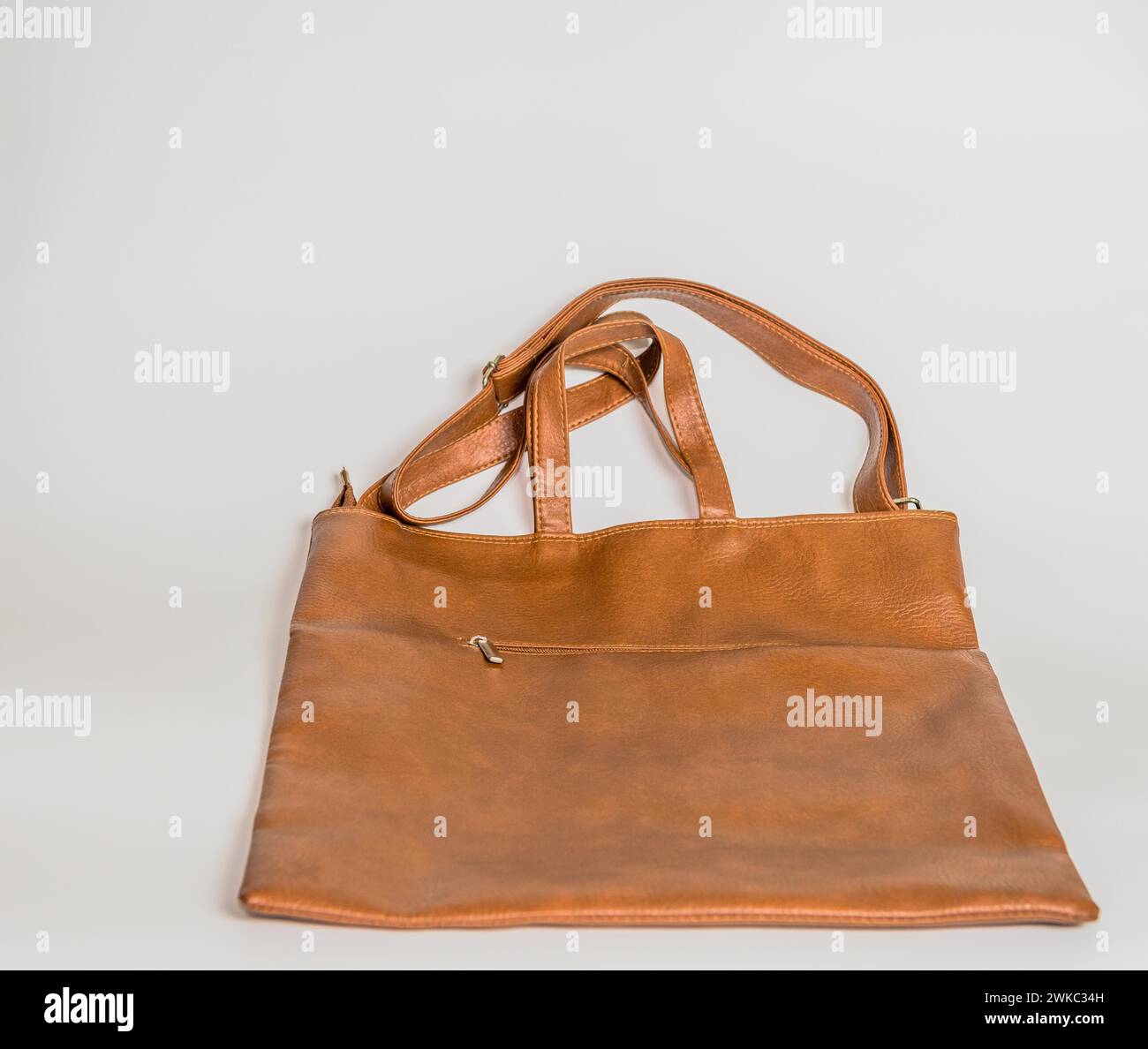 Brown leather shoulder bag with front zipper pocket isolated on white ...