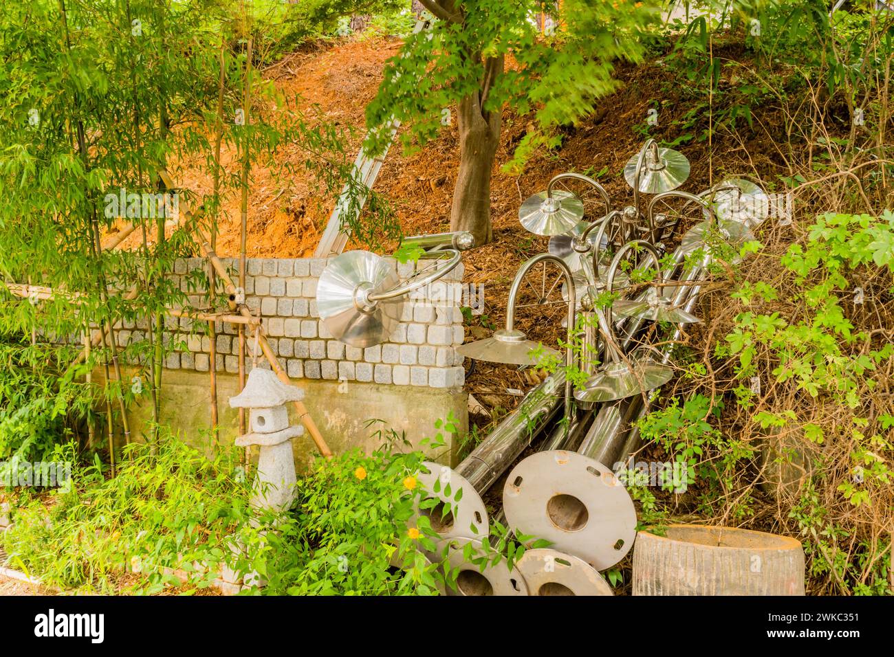 Chrome plated lamp posts laying on hillside in wooded area next to ...