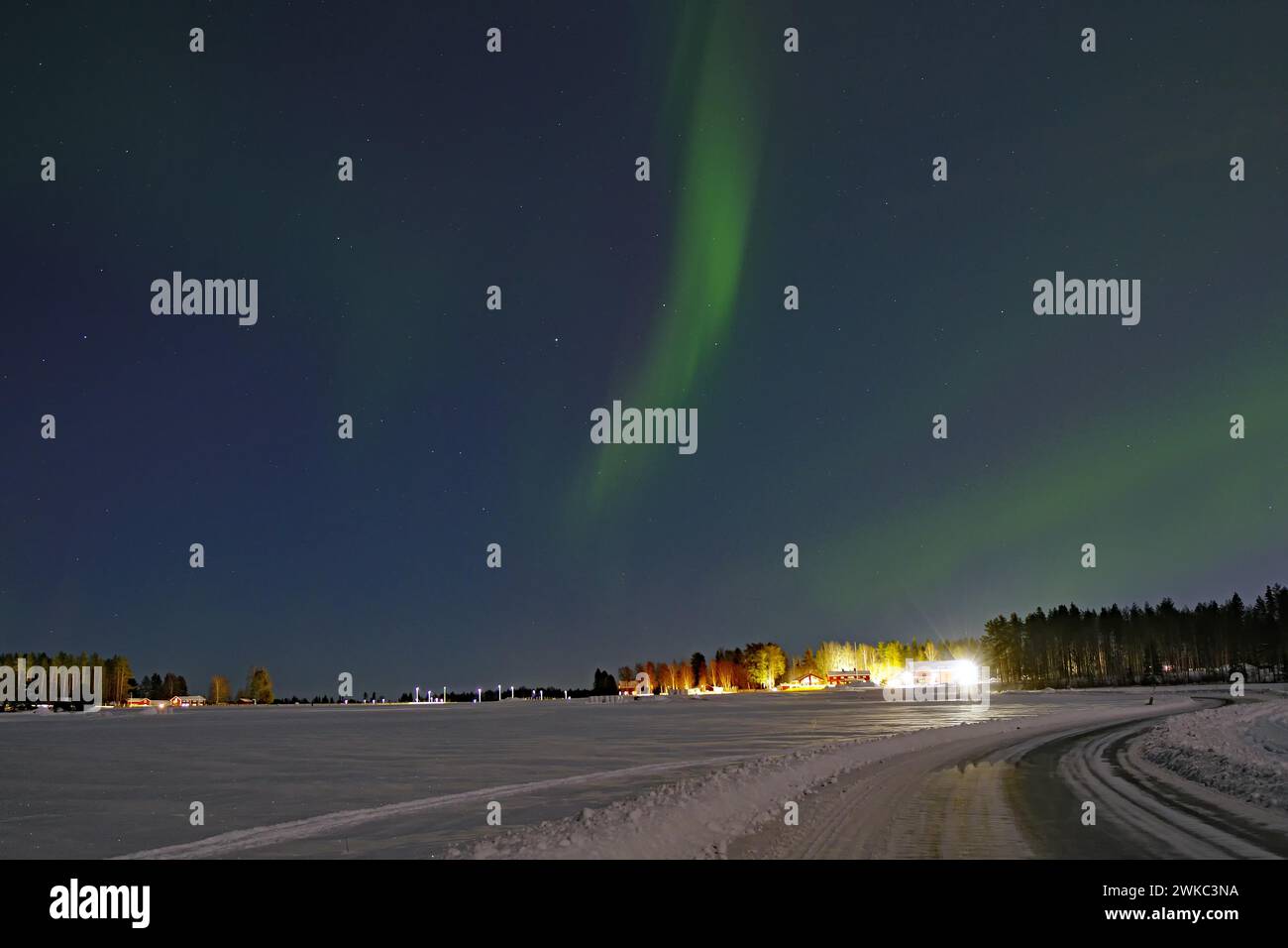 Northern lights over fields and a road, winter landscape, Lulea, Sweden ...