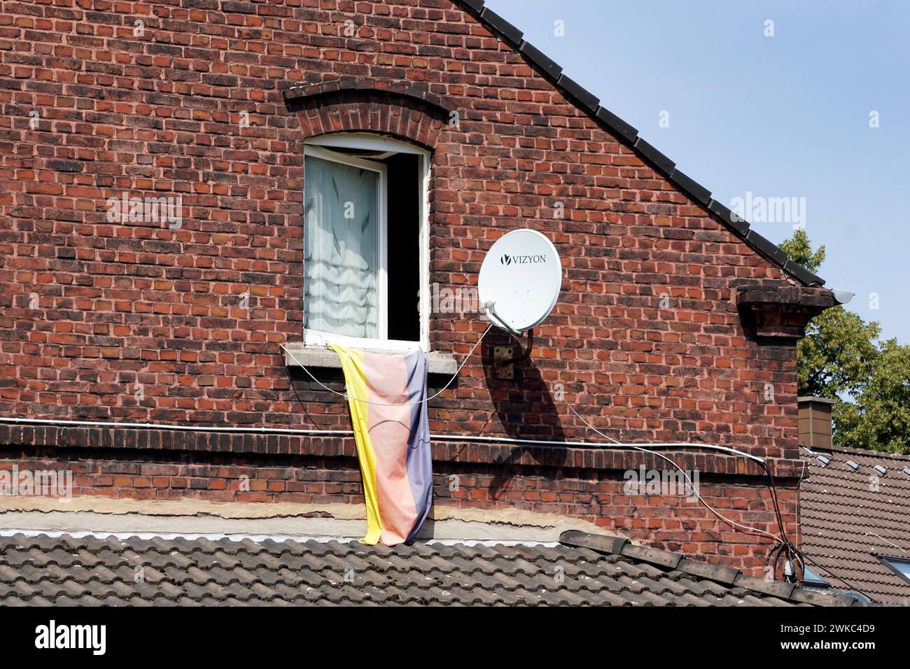 A faded German flag hangs on the window of a house, Essen, 25.07.2019 ...