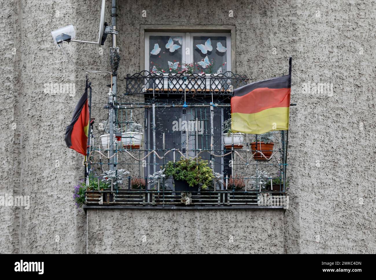 A German flag with a federal eagle flutters on the balcony of a run ...