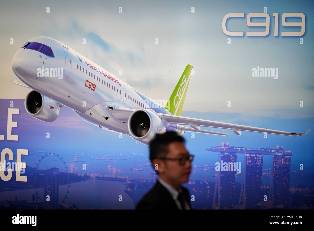 A visitor walks in front of a poster of China's Comac C919 aircraft ...