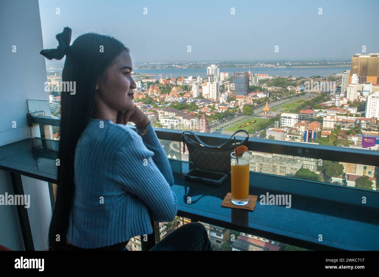Profile of a beautiful young Cambodian woman admiring the aerial view ...