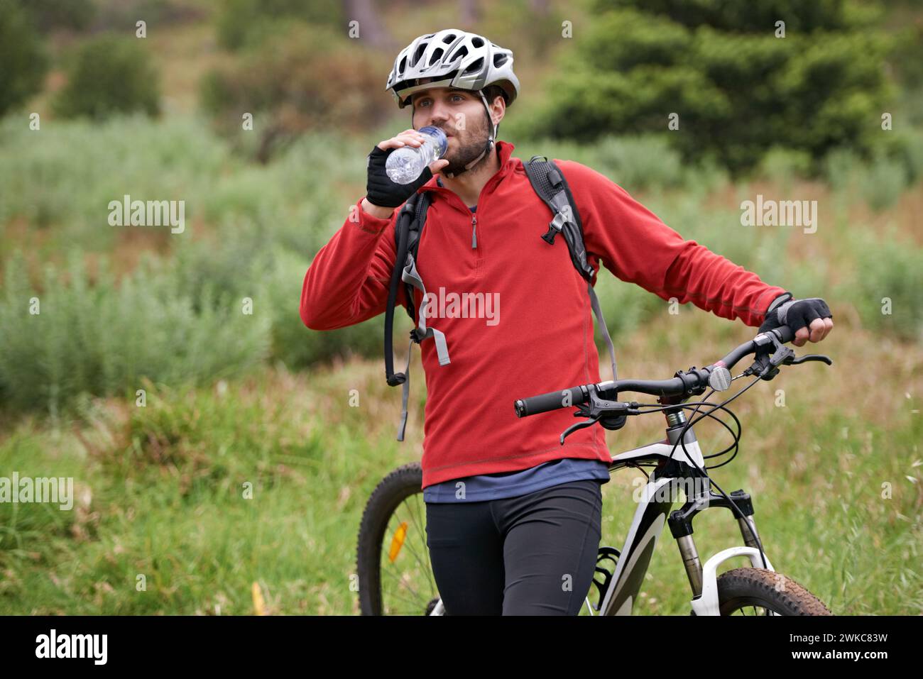 Fitness, bike and man drinking water in countryside for adventure ...