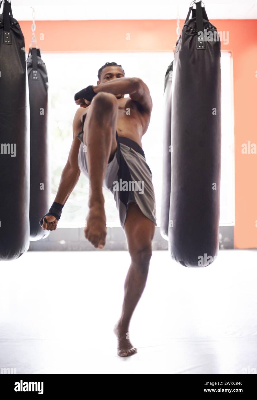 Man, kick boxing and bag with training, knee and combat for exercise ...