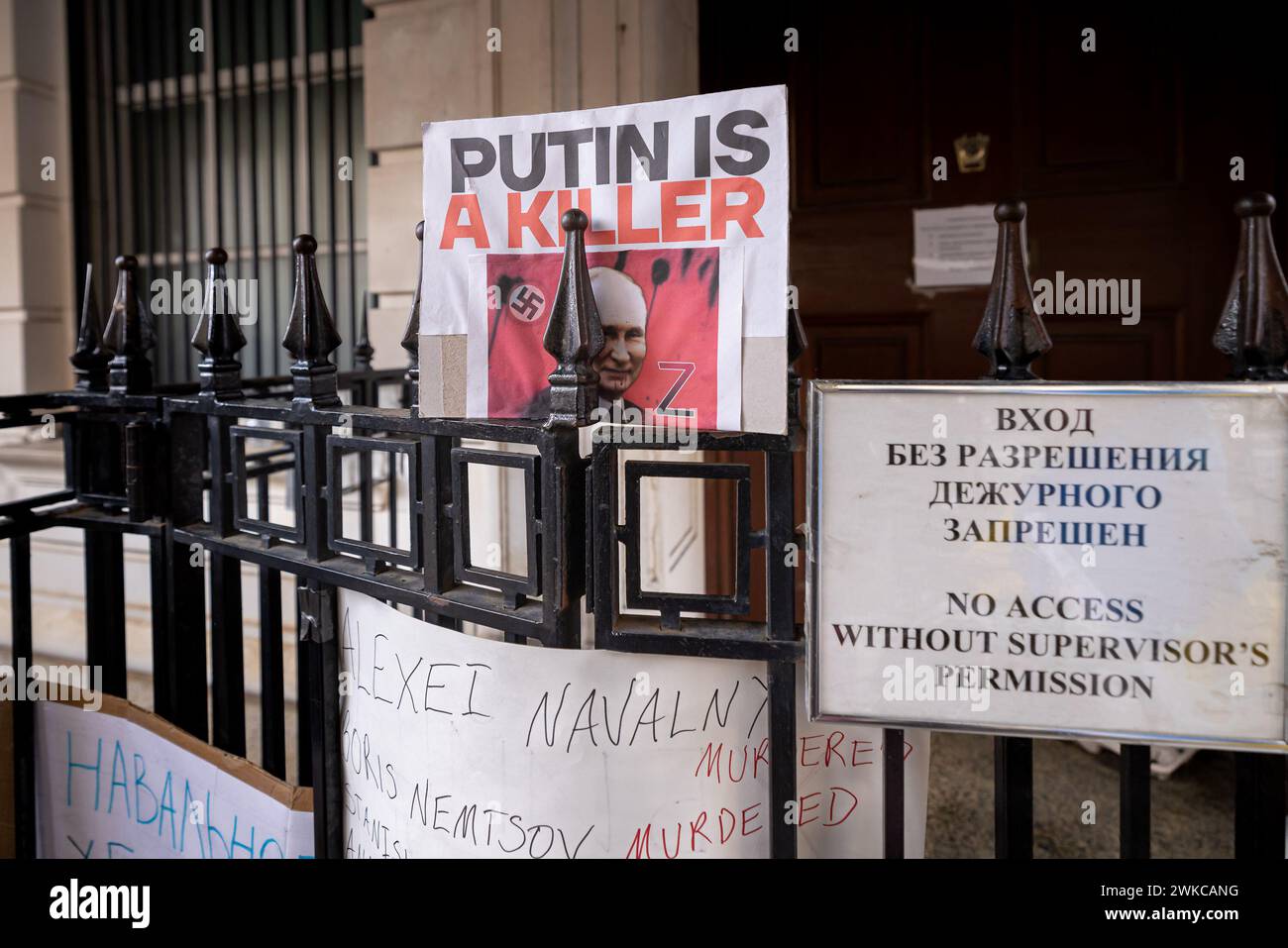 An anti-Putin sign rests on top of the gates of the Russian Consulate ...
