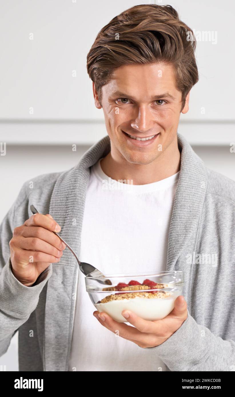 Smile, portrait and man with cereal in kitchen of home for hydration ...