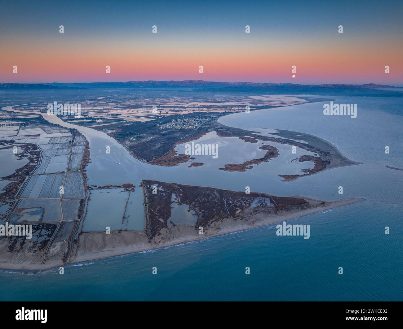 Sunrise over the mouth of the Ebro River in the Ebro Delta with the ...