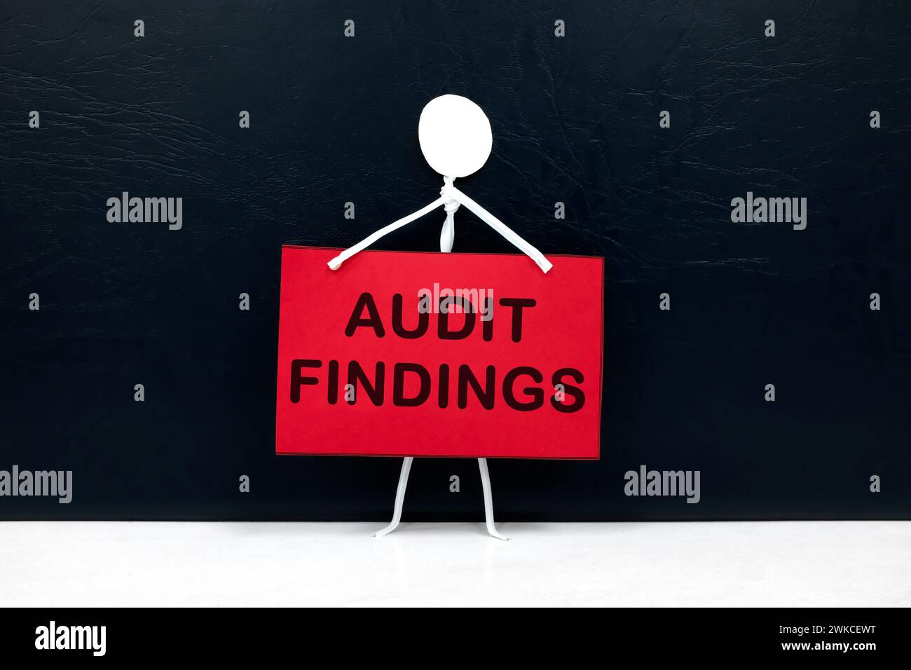 Stick figure holding audit findings placard in black background Stock ...