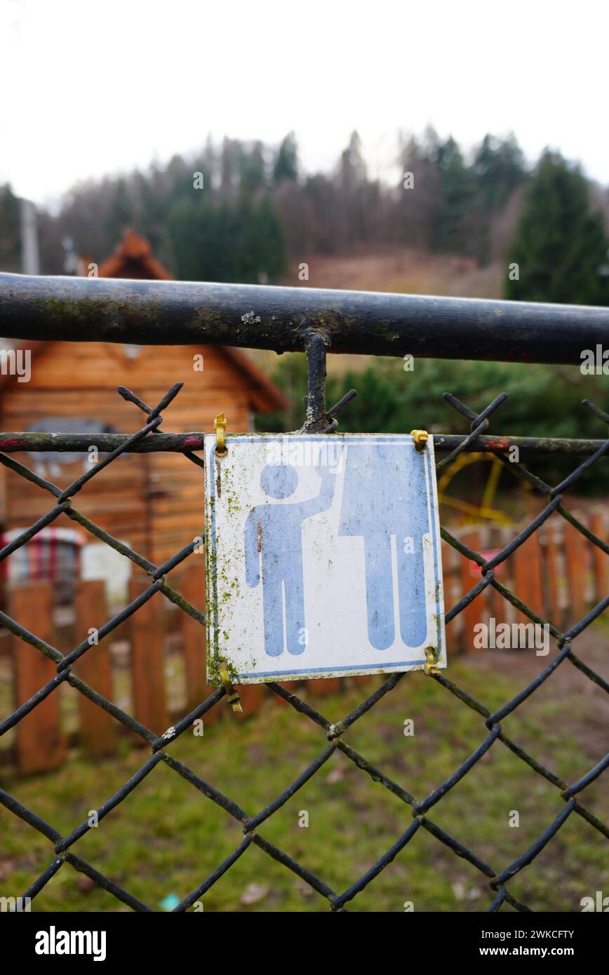 An unlocked gate with a sign attached Stock Photo - Alamy
