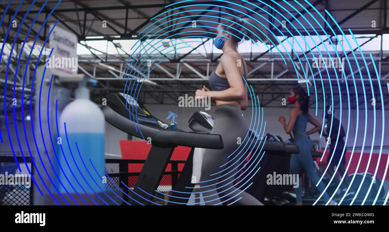 Image of blue spiral rotating over women in face masks exercising on ...