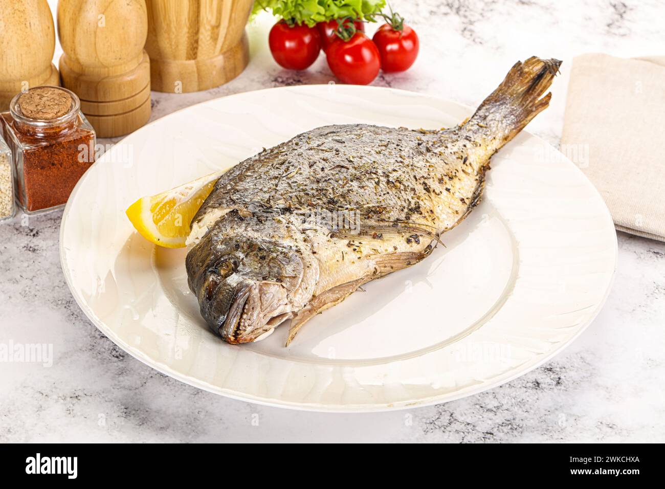 Baked Dorado fish served lemon slice Stock Photo - Alamy