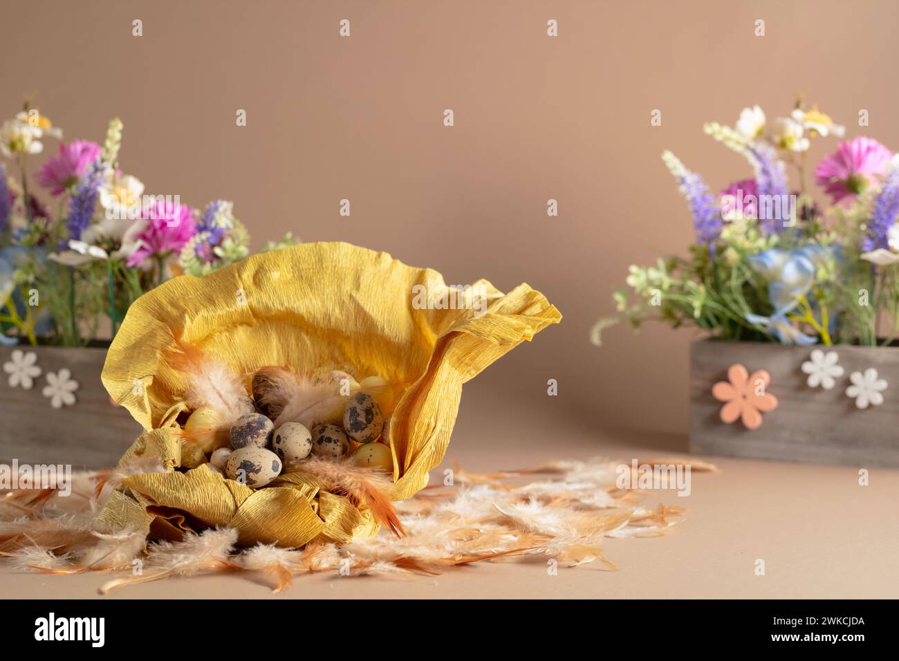 Crepe paper nest with easter eggs, feathers, and spring flowers on a ...
