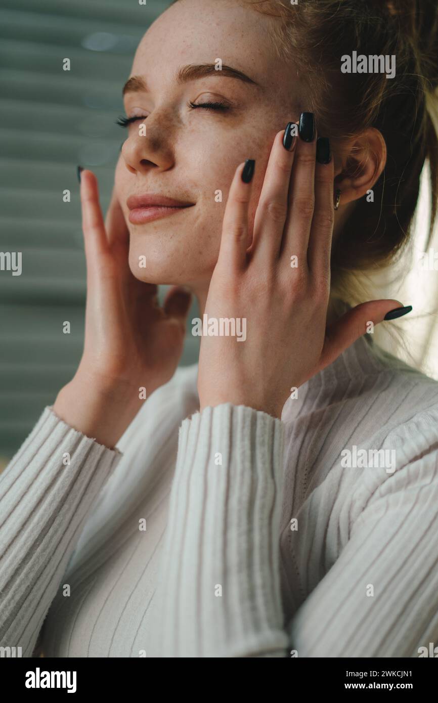 Beautiful young lady touching face enjoying healthy soft moisturized ...