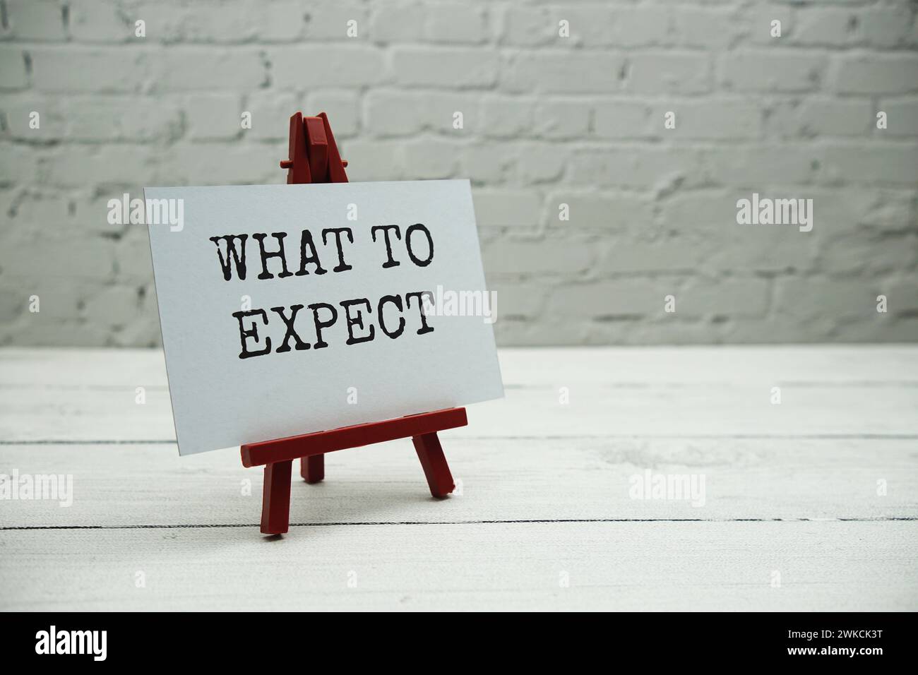 What to Expect? text on white brick wall and wooden background Stock ...