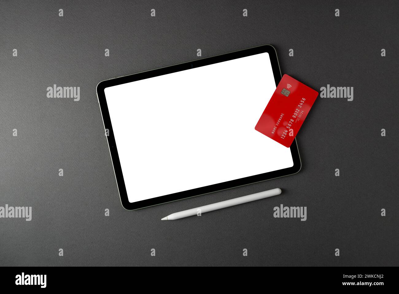 Credit card lying on tablet with blank screen on dark gray table Stock ...