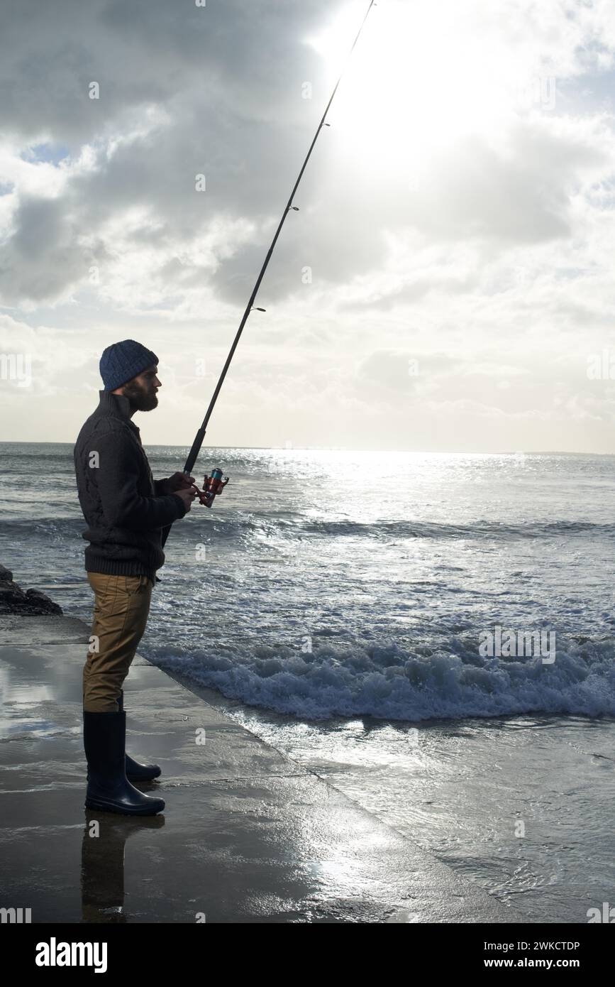 Thinking, fishing and man at a beach with pole for water hobby ...