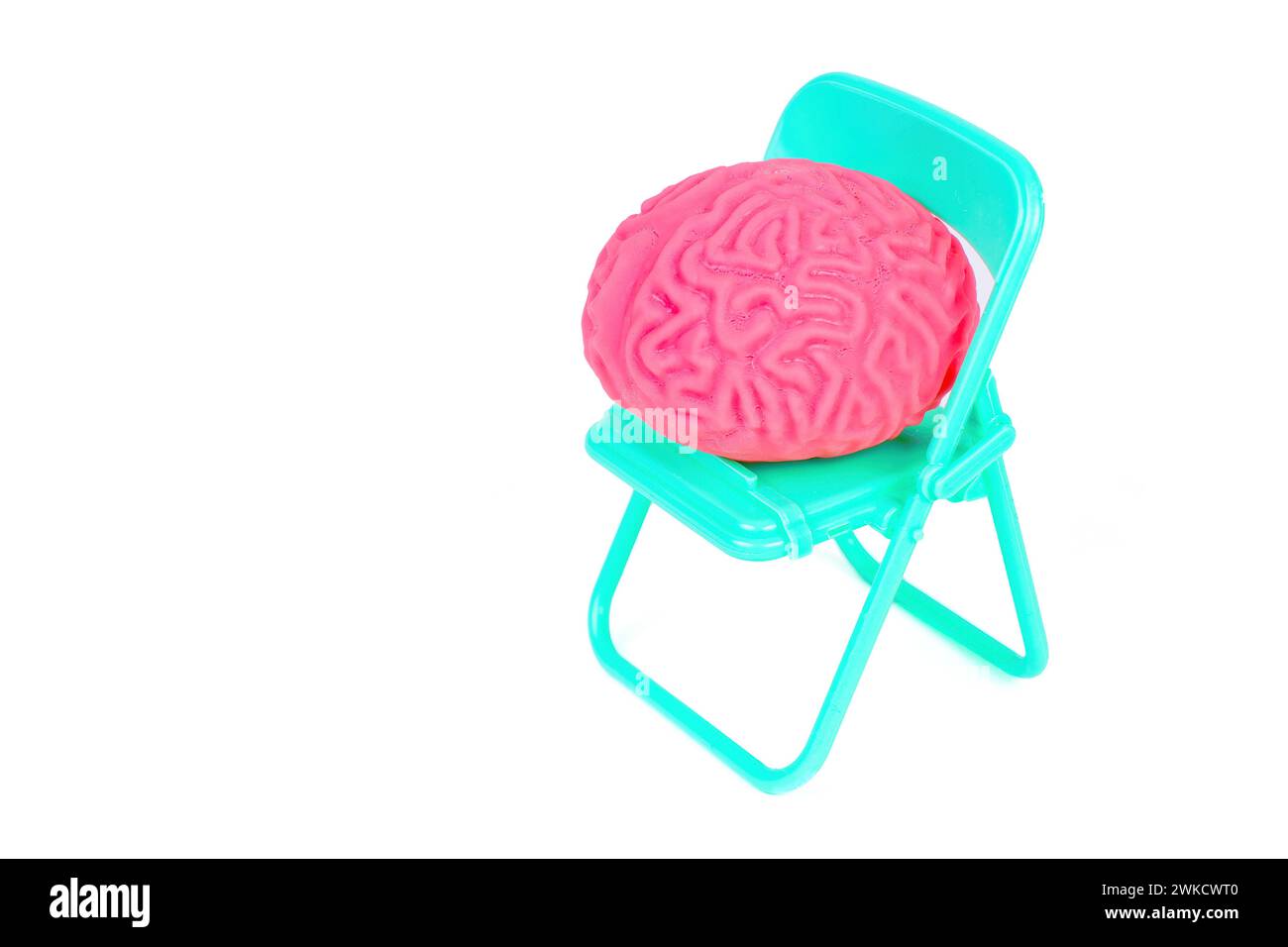 Soft pink human brain set on a foldable teal chair isolated on white ...