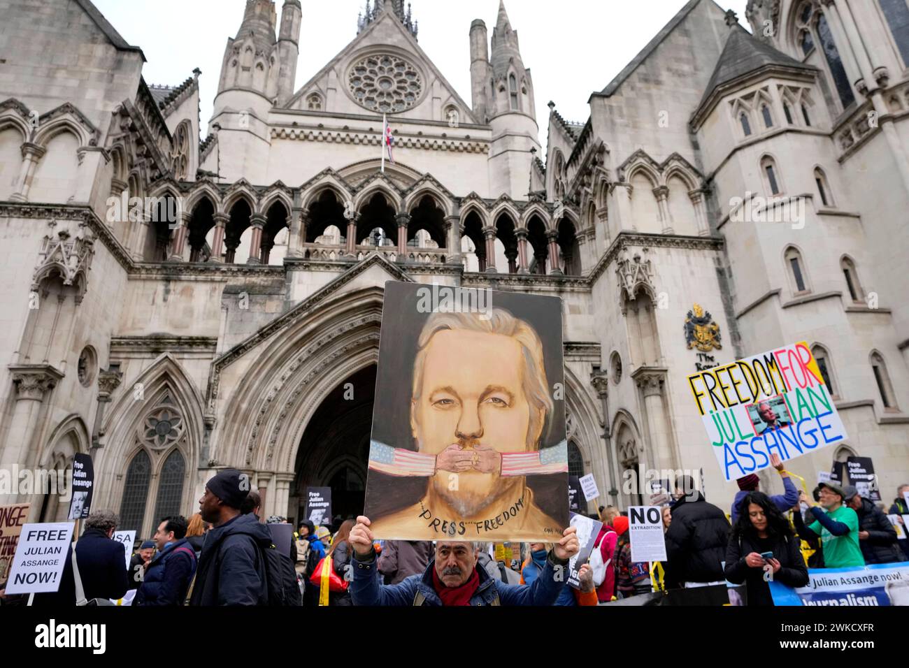 Artist Kaya Mar holds up his painting of Julian Assange as ...