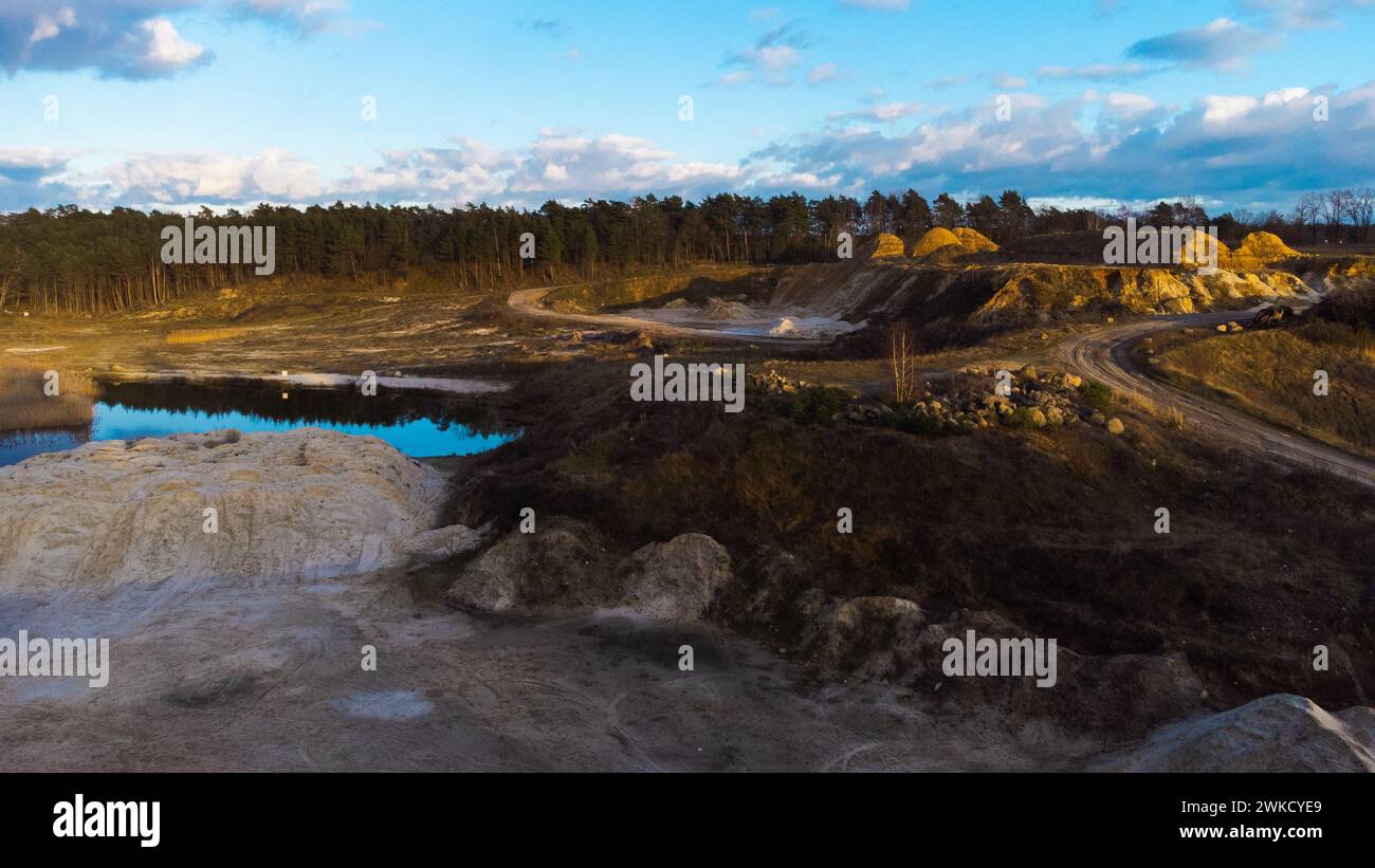 A collection of expansive quarries with azure water and earthy terrain ...