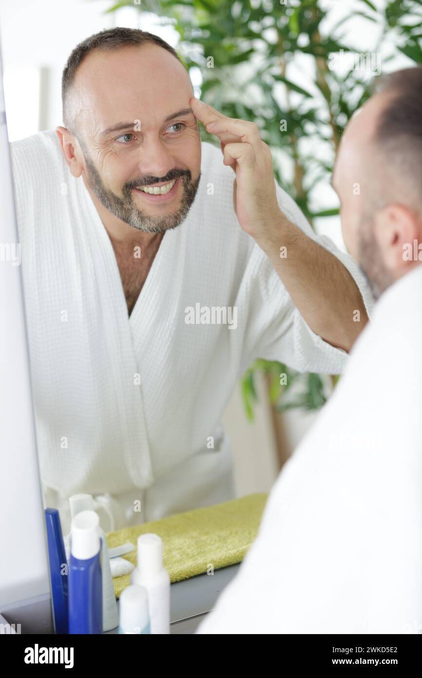 Mature man touching skincare hi-res stock photography and images - Alamy