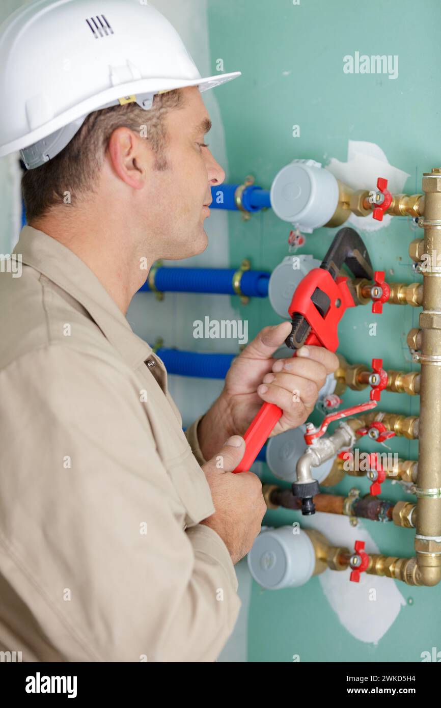 male plumber fixing water meter with adjustable wrench Stock Photo - Alamy