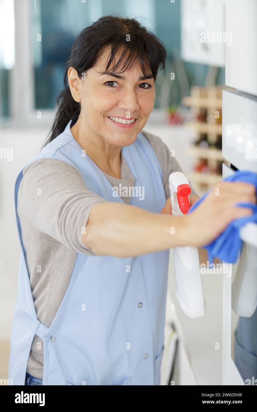 woman in blue wiping dust from wall and cleaning home Stock Photo - Alamy