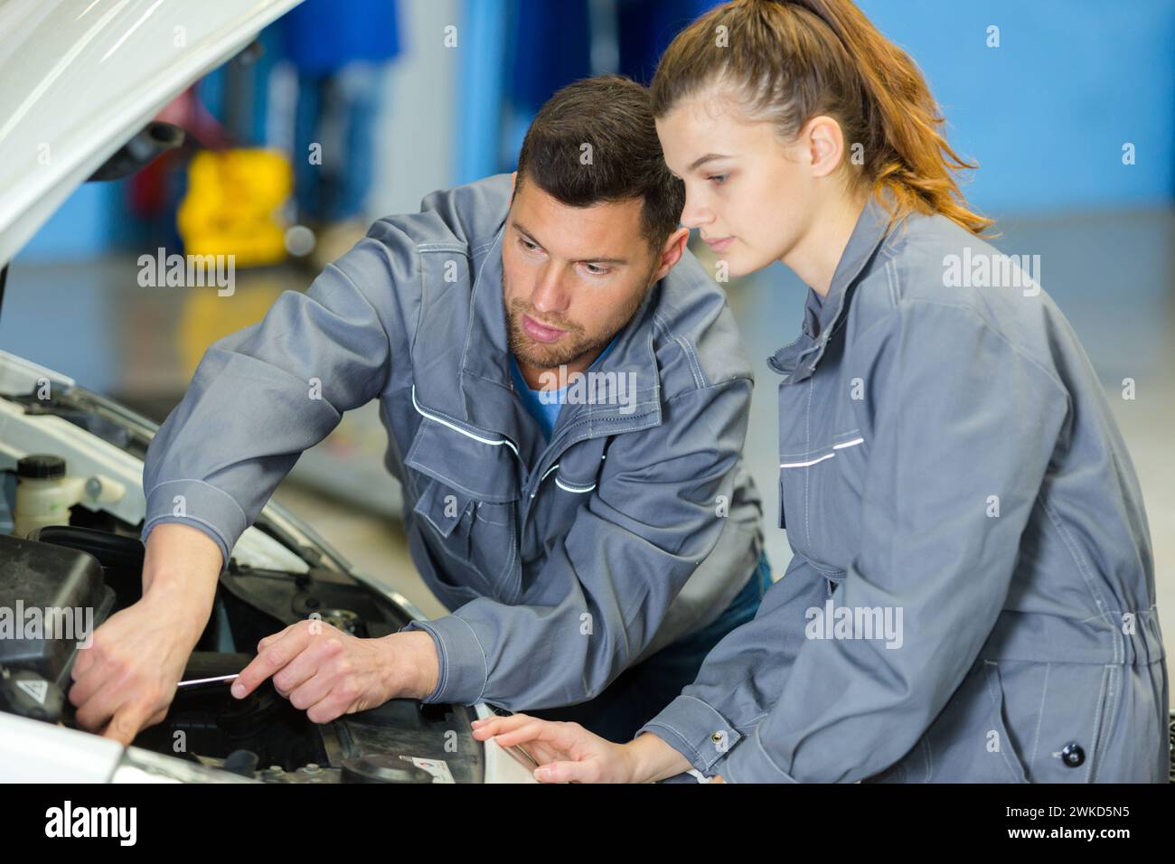 portrait two positive workers fixing car to satisfied client Stock ...