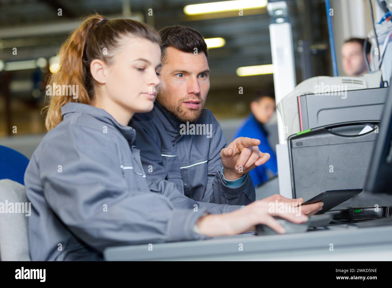teacher helping students with laptop Stock Photo - Alamy