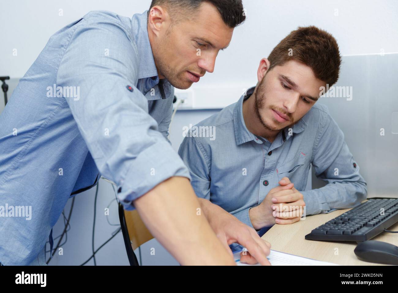 Two men instructing worker hi-res stock photography and images - Alamy