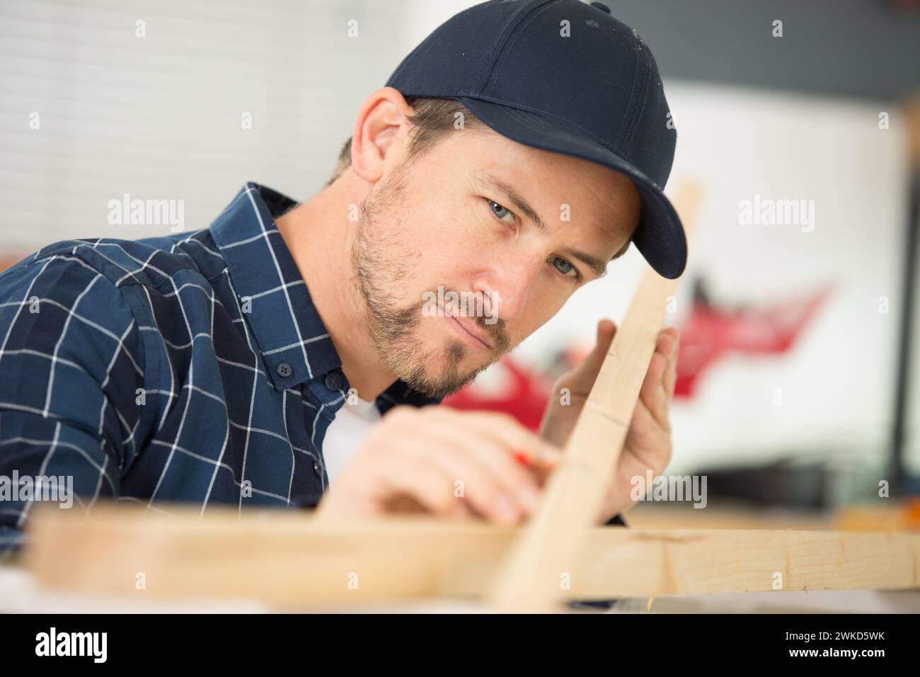 carpenter looking down the length of a piece of wood Stock Photo - Alamy