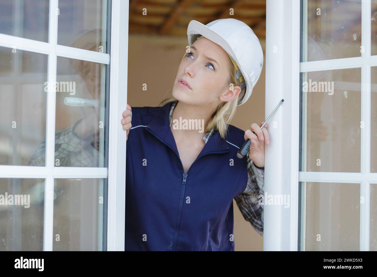 a young woman installing windows Stock Photo - Alamy