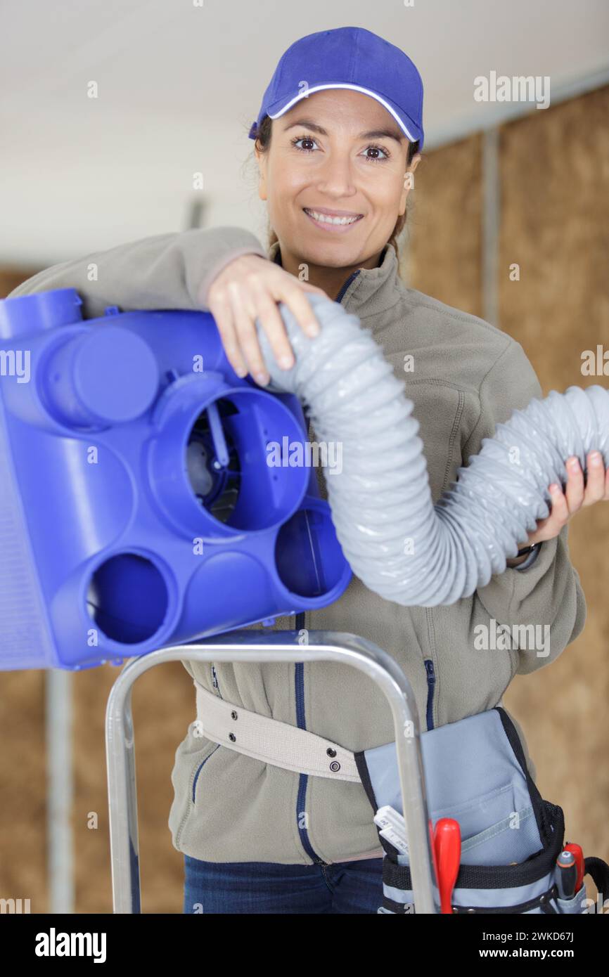female worker fitting air conditions pipe Stock Photo - Alamy