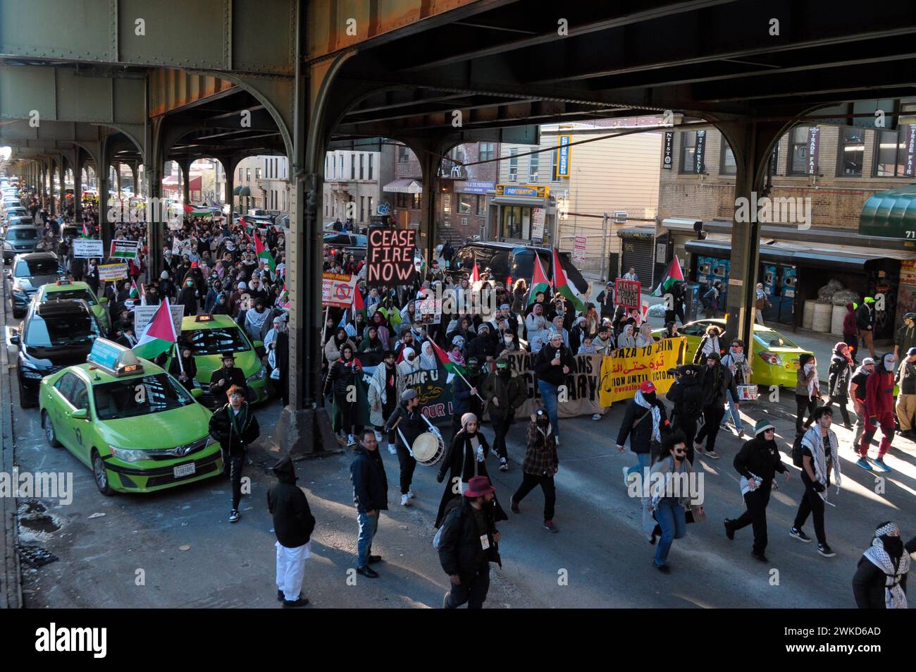 Pro-Palestine demonstrators march waving Palestinian flags and holding ...