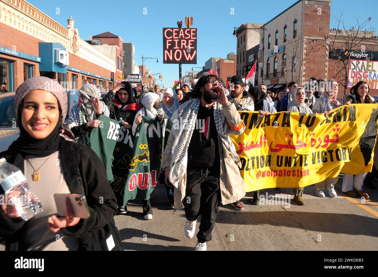 Pro-Palestine demonstrators march waving Palestinian flags and holding ...