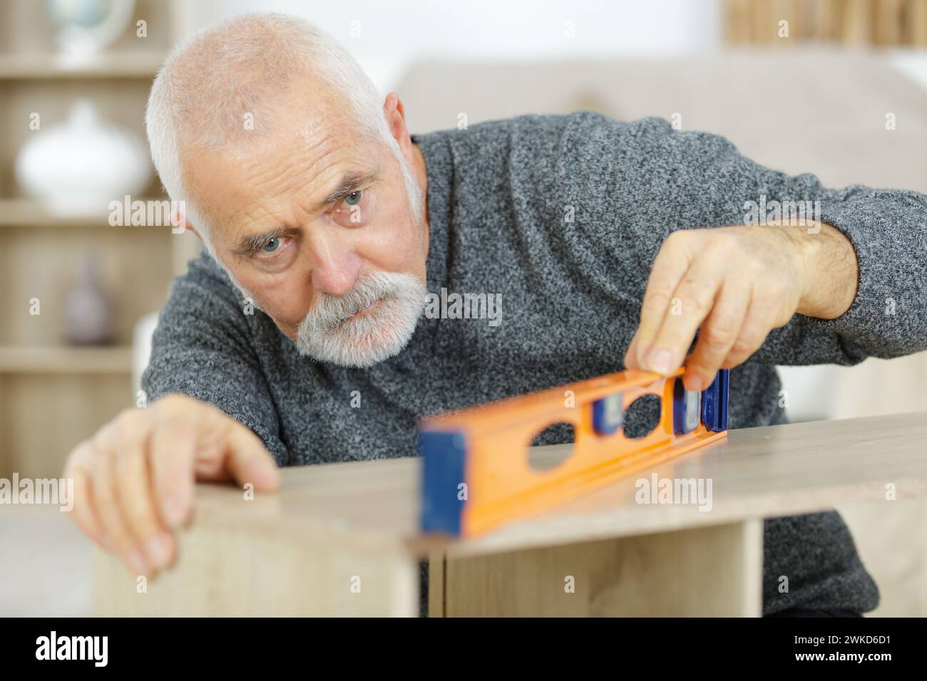 mature male checking wood level Stock Photo - Alamy