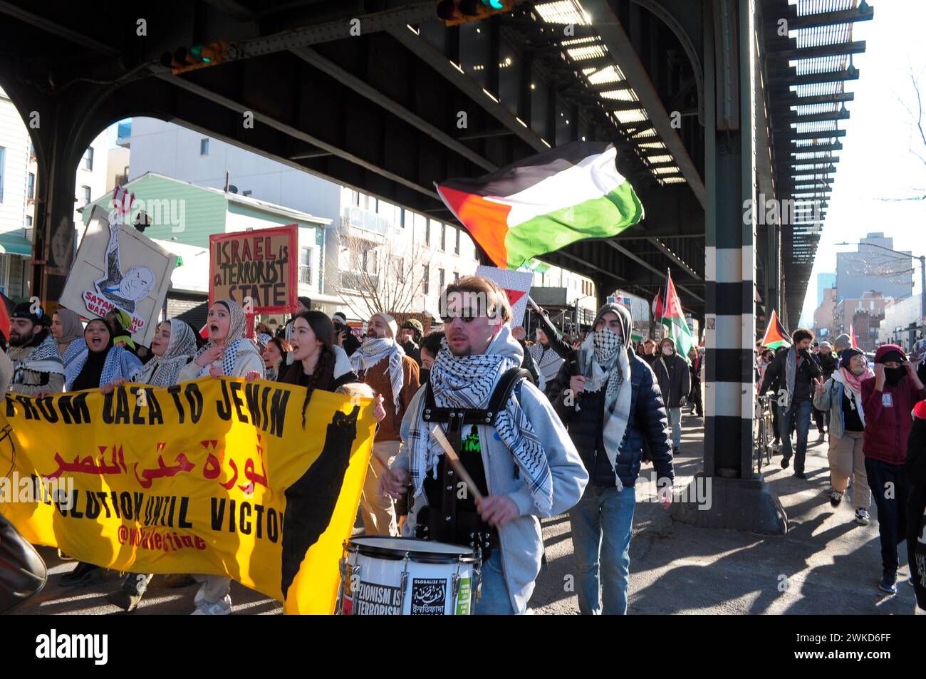 Pro-Palestine demonstrators march waving Palestinian flags and holding ...