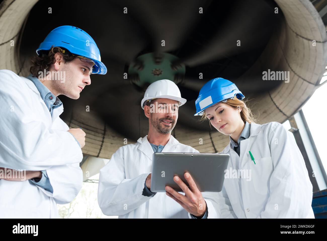 men and woman engineers using tablets for monitoring factory Stock ...