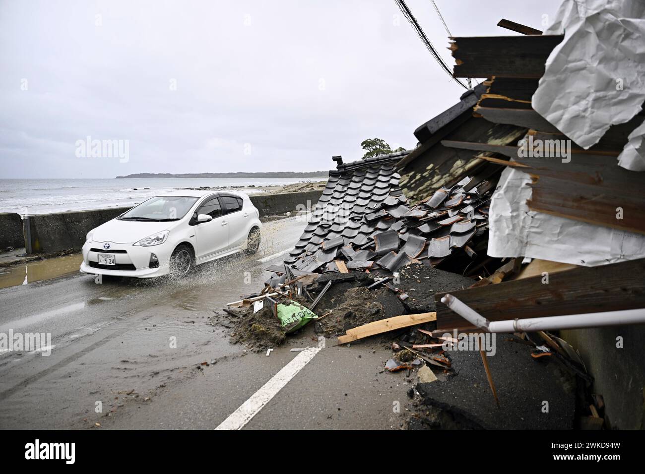 Wreckage of a collapsed house blocks a road in Suzu in the central ...