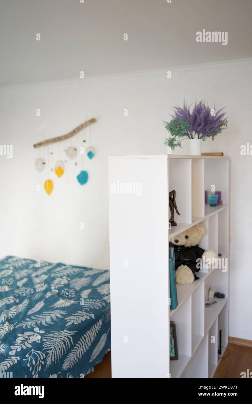 white shelf divides the room into two parts, separating the work area ...