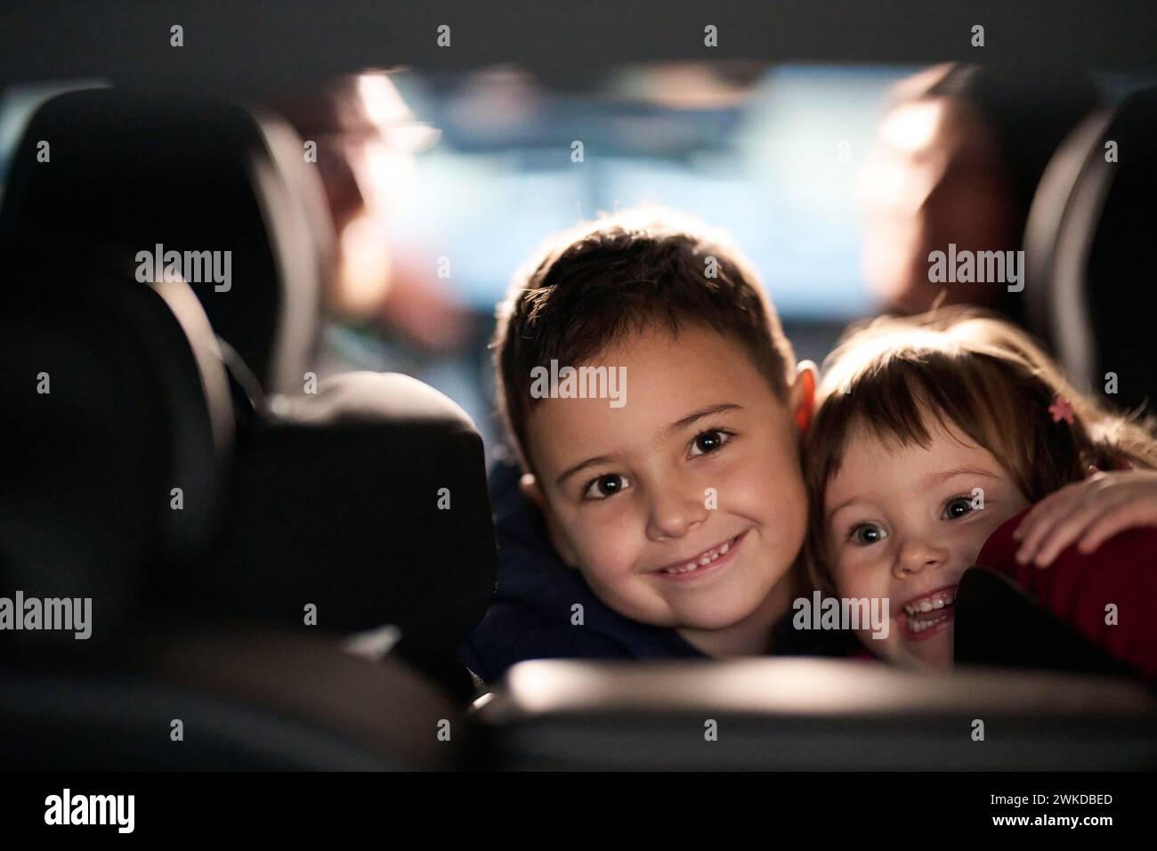 A young brother and sister enjoying a car ride together, immersed in ...