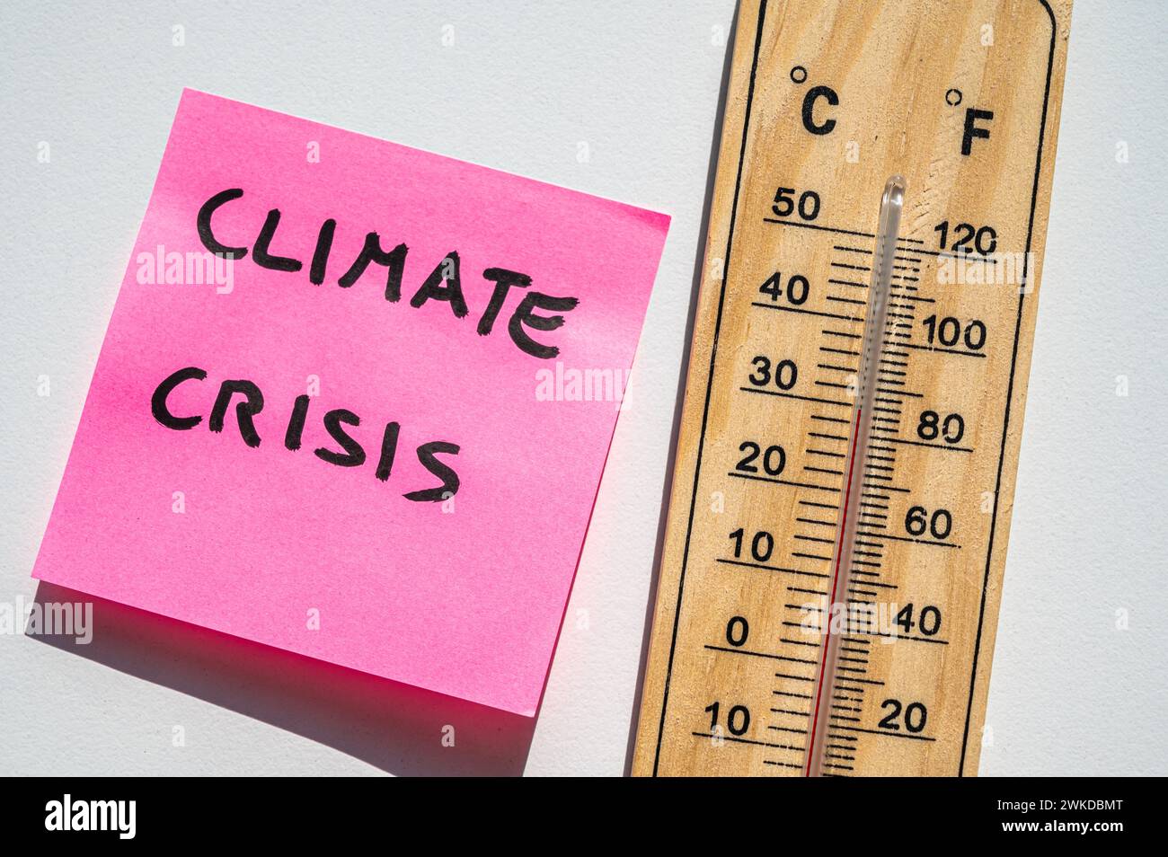 Thermometer on a light surface, and next to a note with the text ...