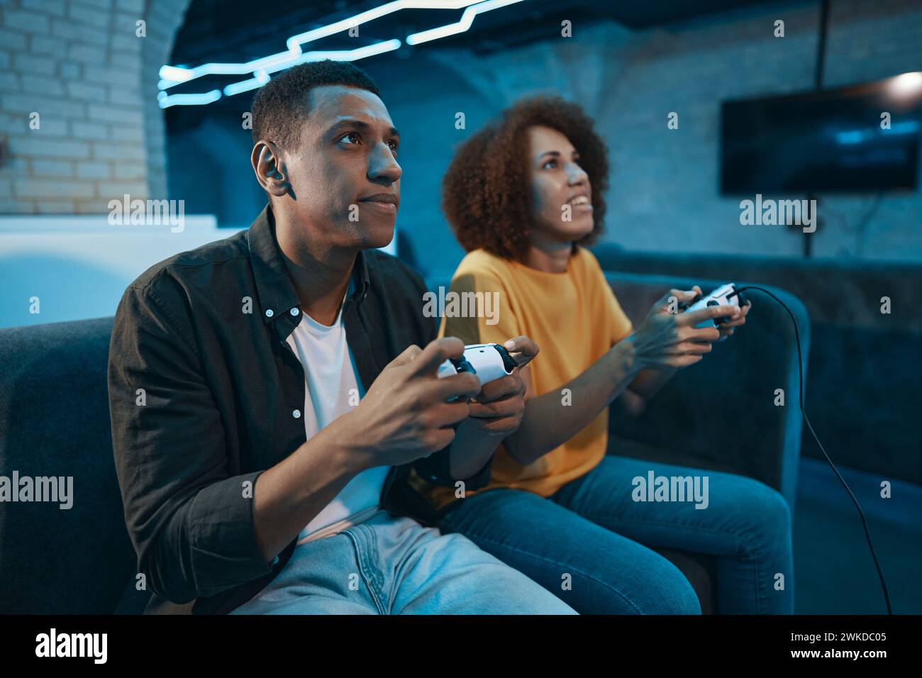 Man and woman play console and show emotions Stock Photo - Alamy