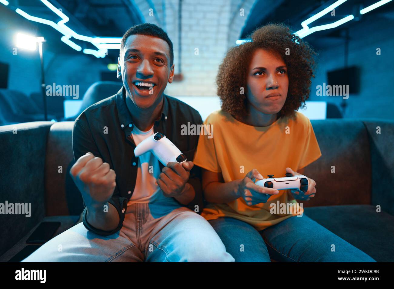 Man and woman play console and show emotions Stock Photo - Alamy