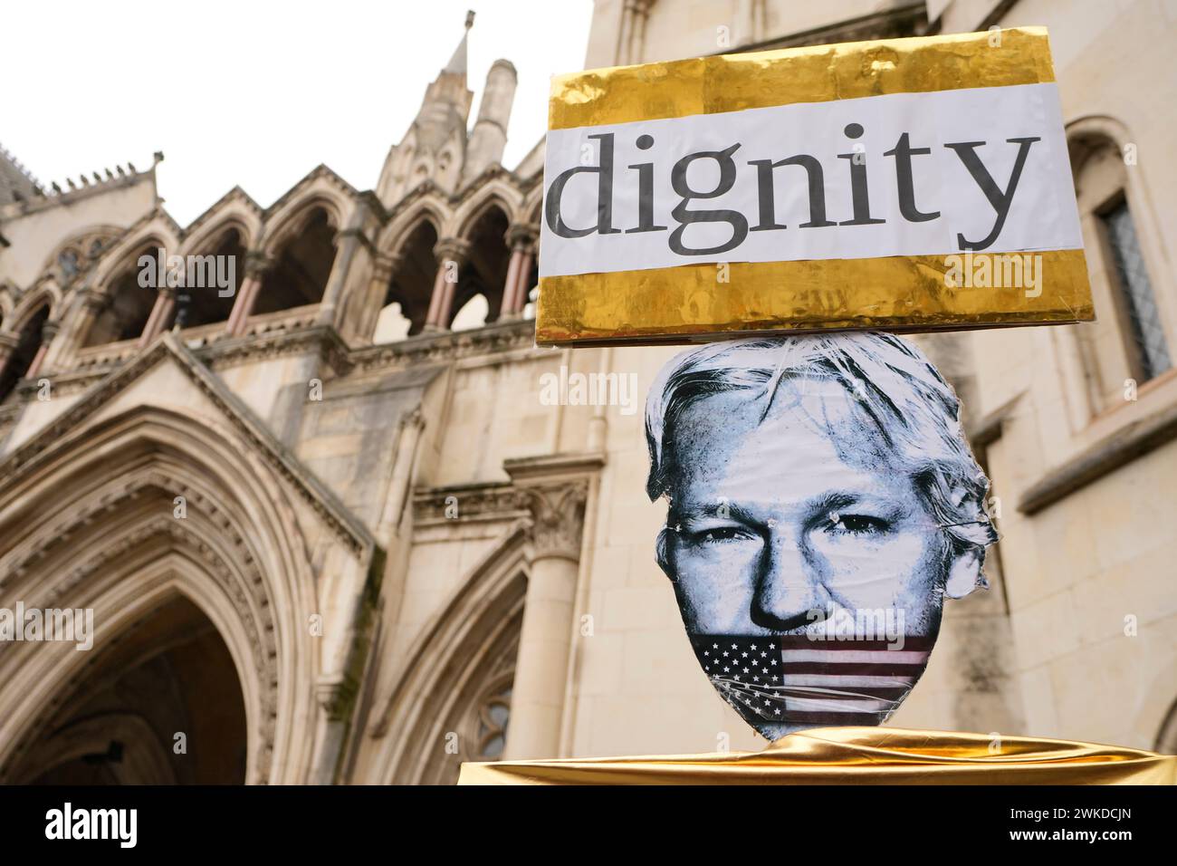 A mask showing the face of Julian Assange is held outside the Royal ...