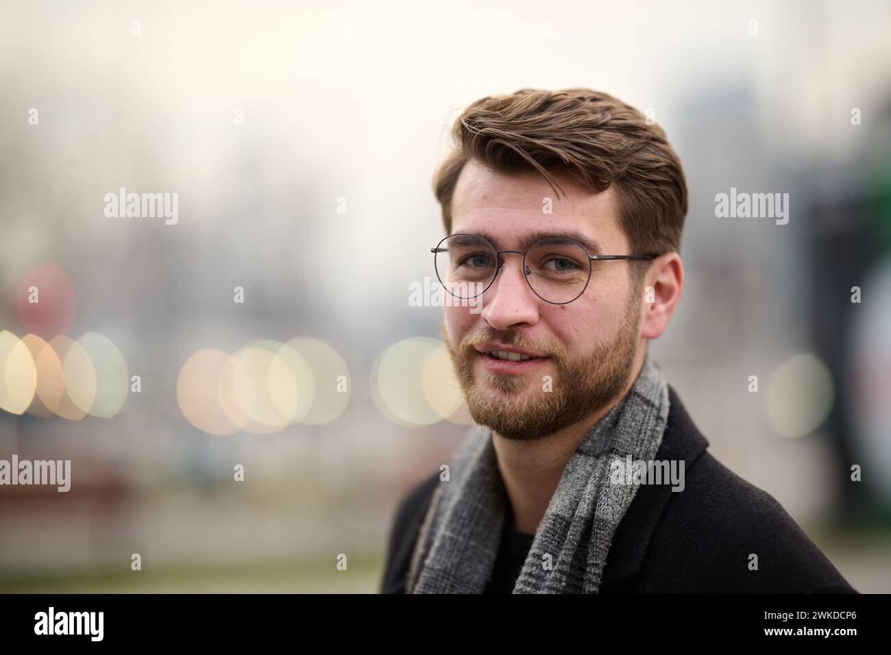 A handsome young man, dressed in a stylish suit, tie, and glasses ...