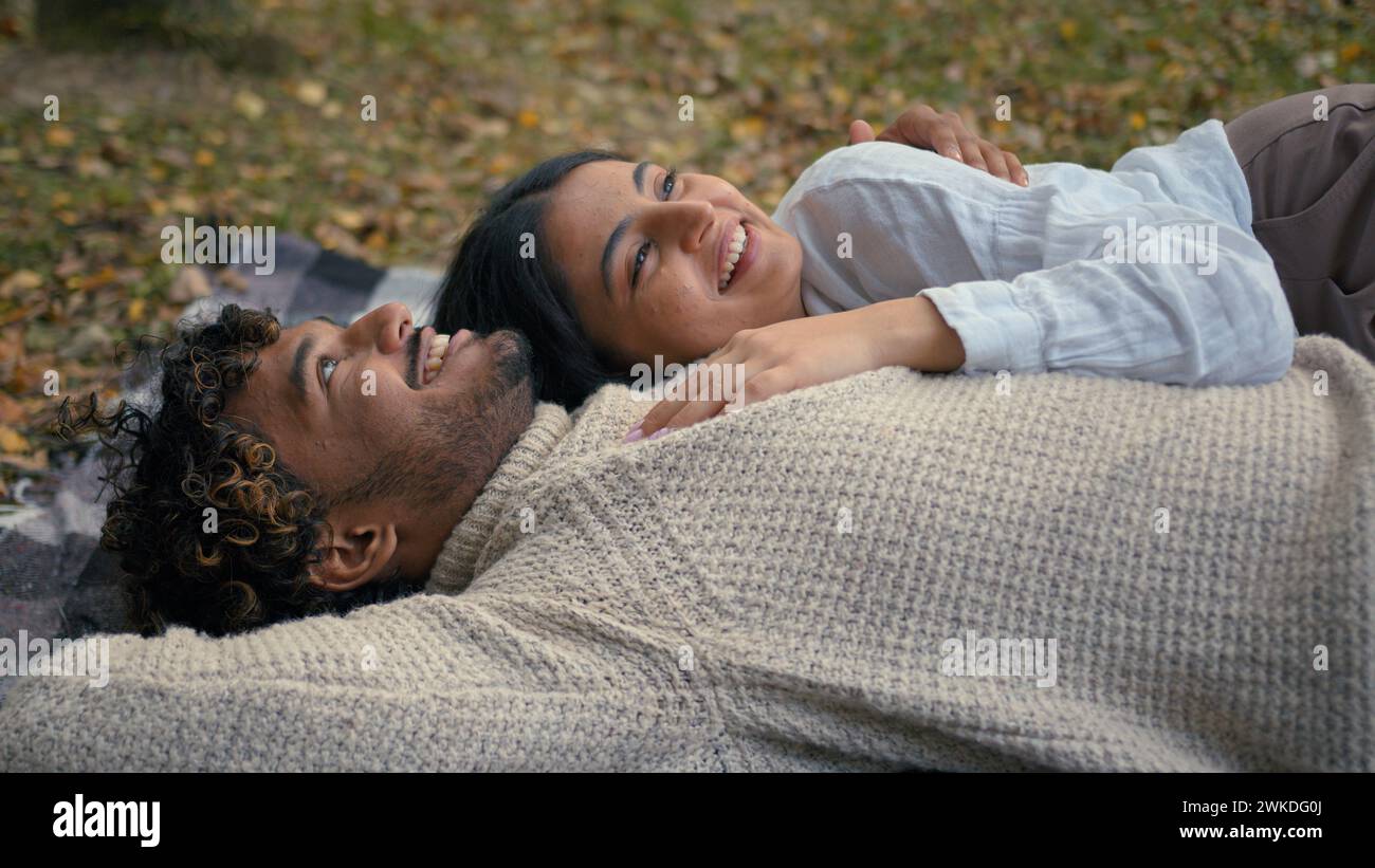 Romantic date in autumn park Indian Arabian couple in love boyfriend girlfriend talking smiling ...