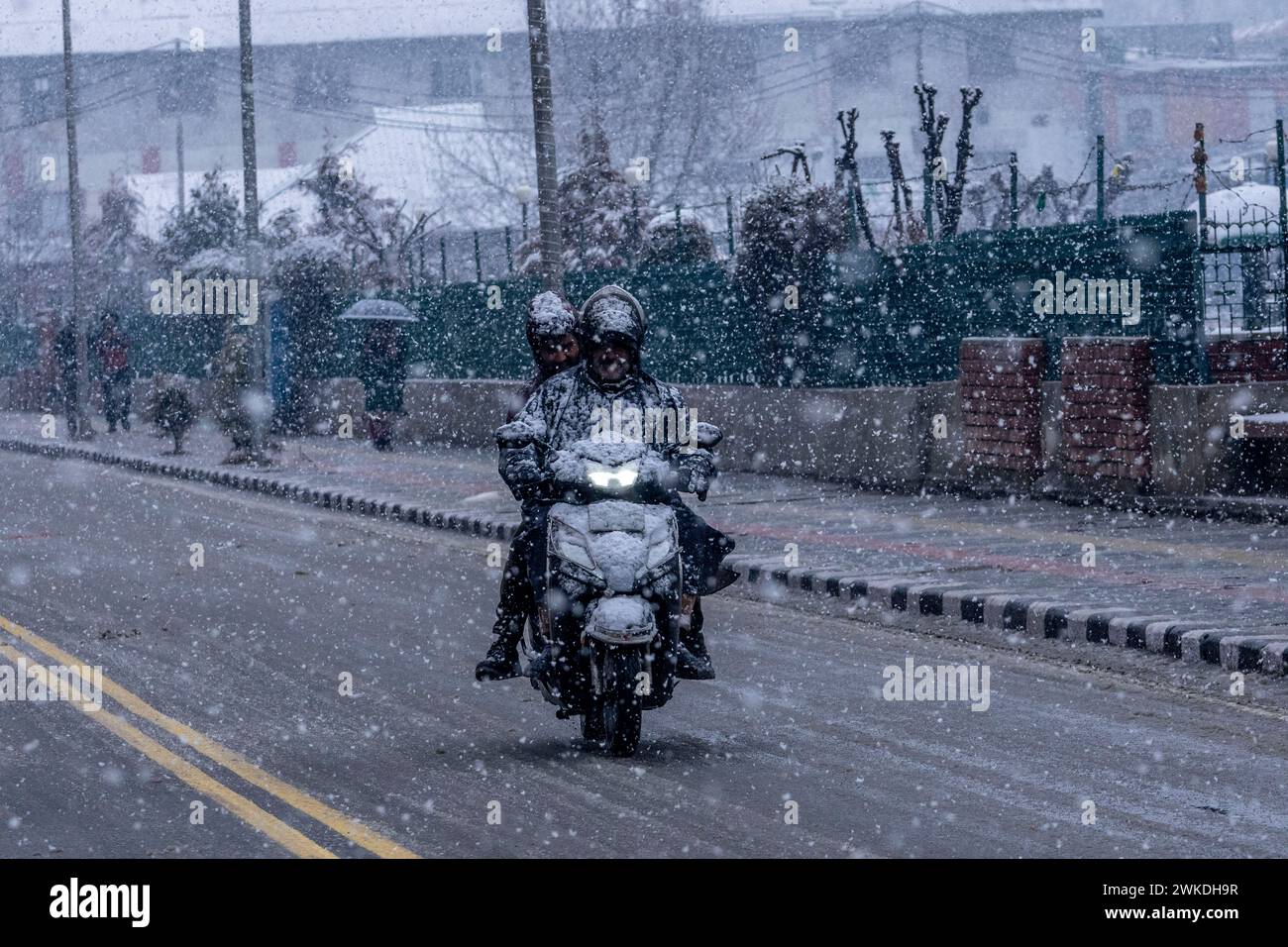 Two Kashmiri men take a scooter ride during a fresh snowfall in ...