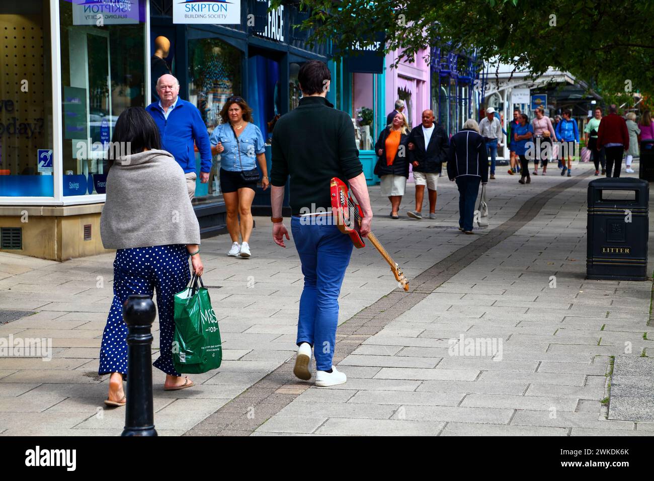 Shoppers walking on the pavement along The Grove Ilkley Yorkshire UK ...